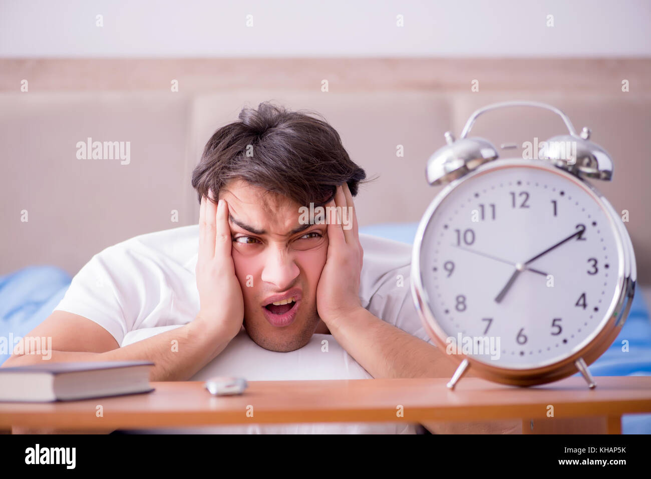 Man in bed frustrated suffering from insomnia with an alarm clock Stock ...