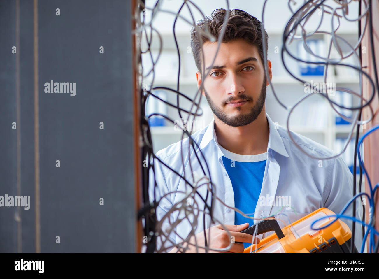 Electrician trying to untangle wires in repair concept Stock Photo - Alamy