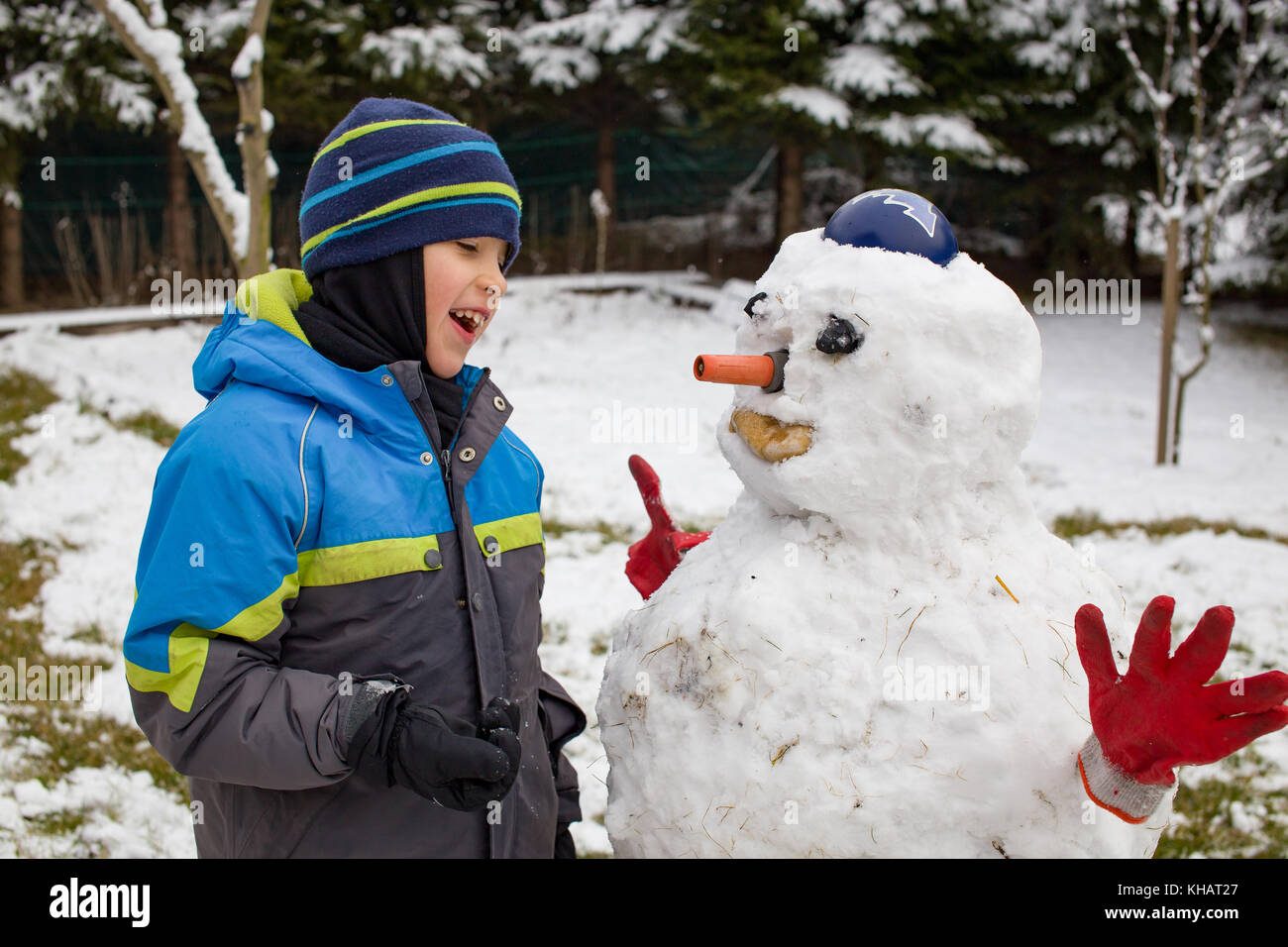 A child - boy with his self created snowman. Winter time in Poland ...