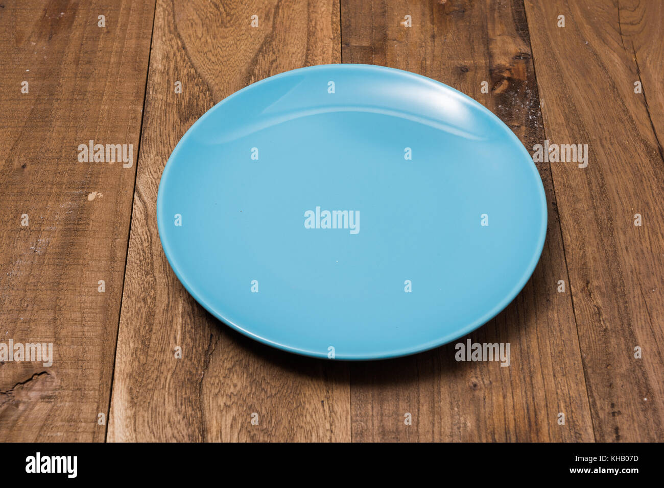 Blue Round Plate on brown wooden table background side view Stock Photo ...