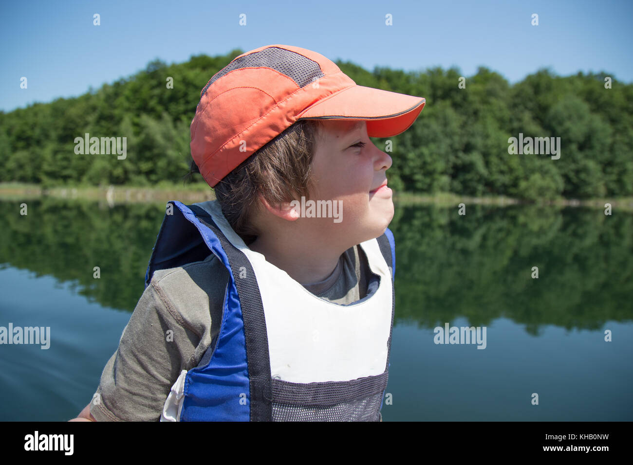 Boy driving a boat with electric outboard motor on a lake in Poland ...