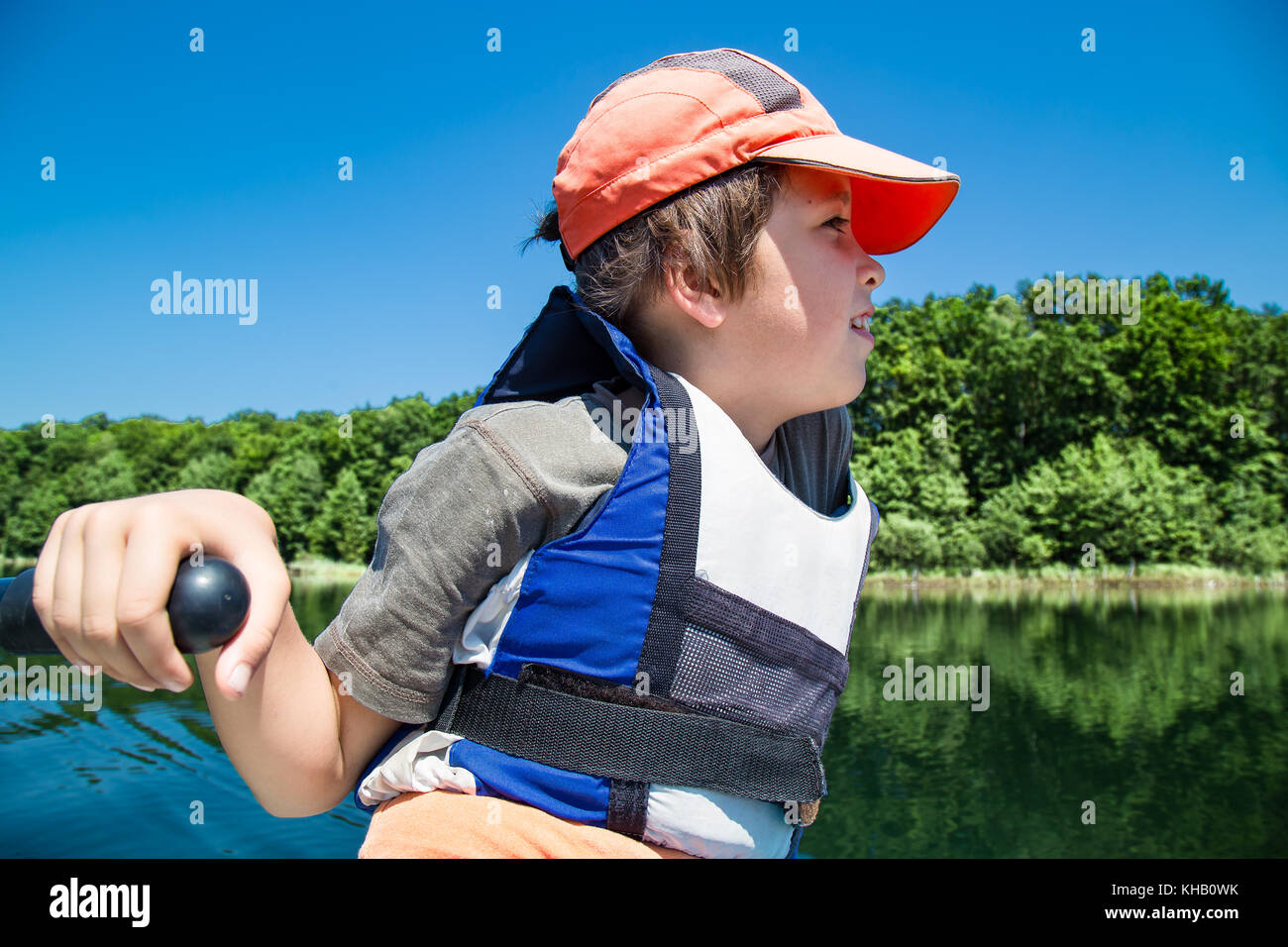 Boy driving a boat with electric outboard motor on a lake in Poland ...
