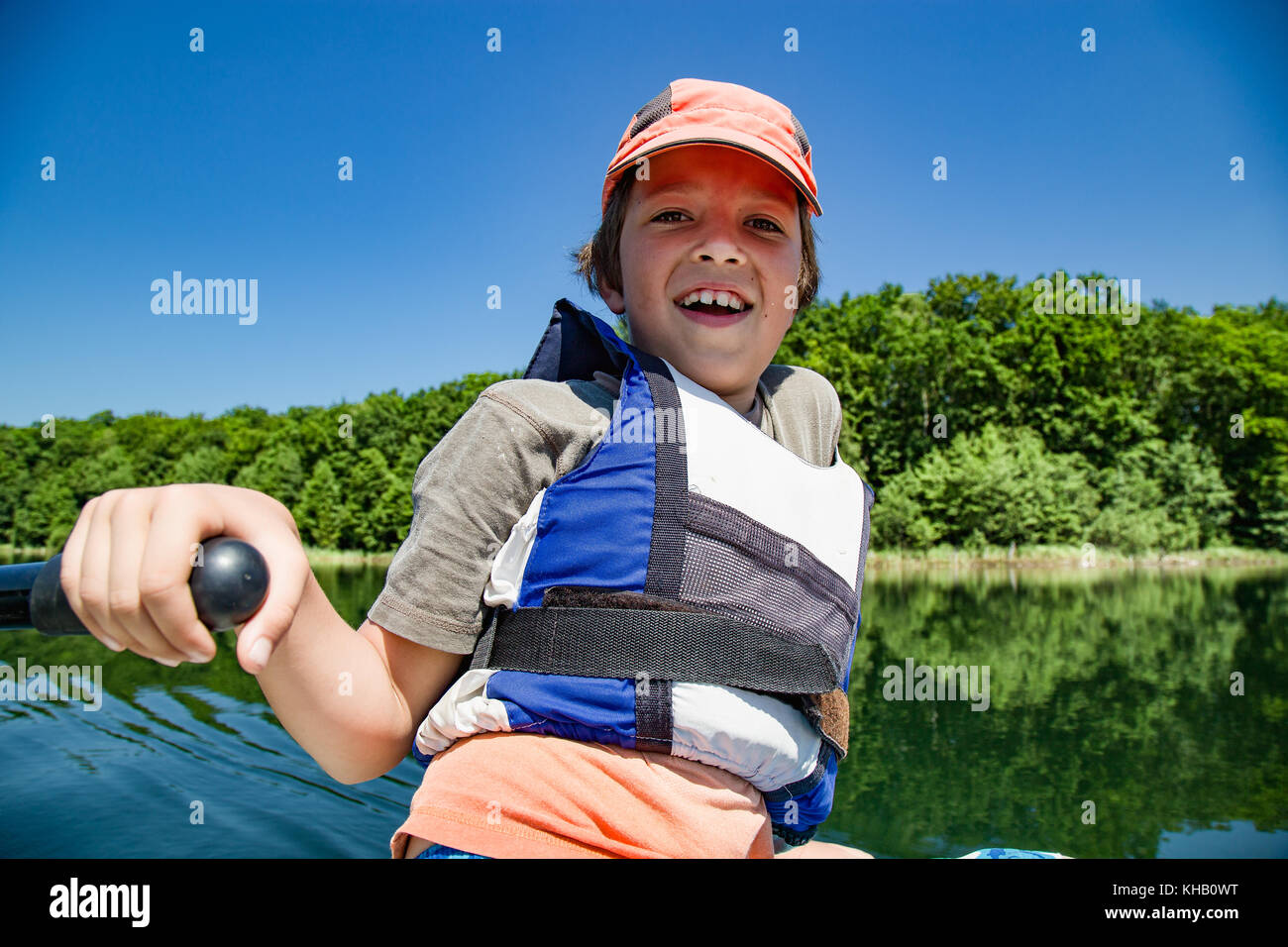 Boy driving a boat with electric outboard motor on a lake in Poland ...