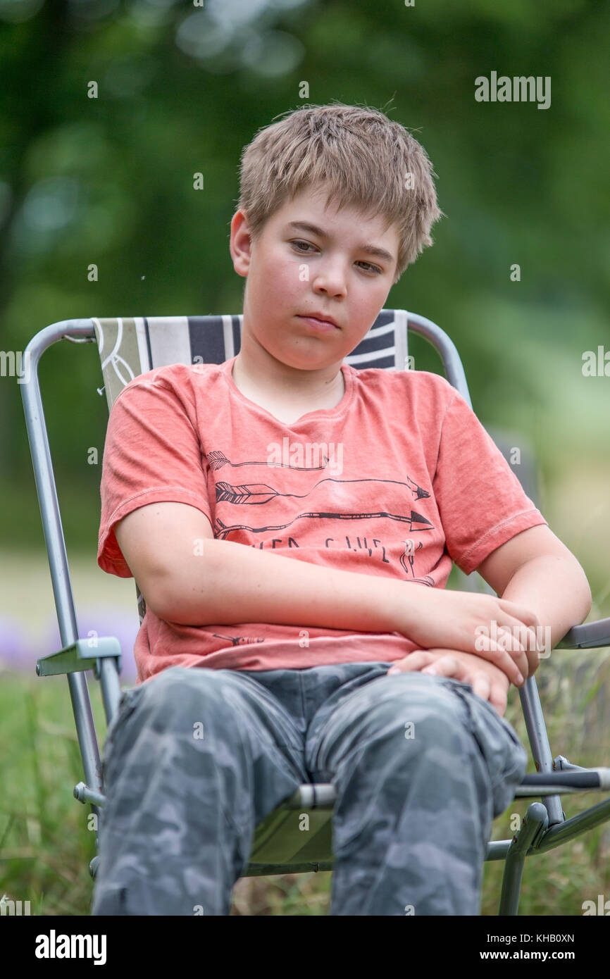 A tired boy sitting relaxed and resting after playful time on the ...