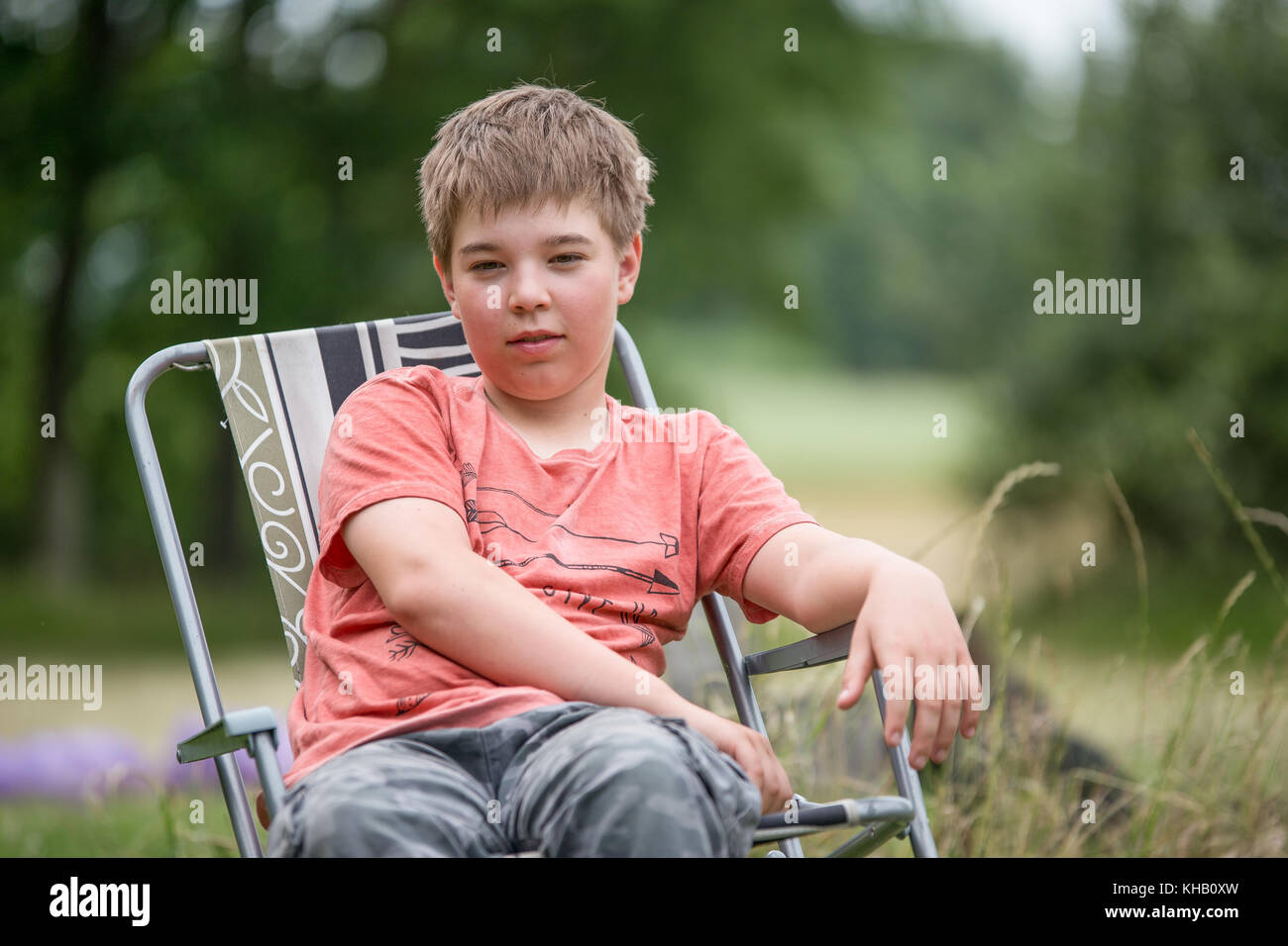 A tired boy sitting relaxed and resting after playful time on the ...