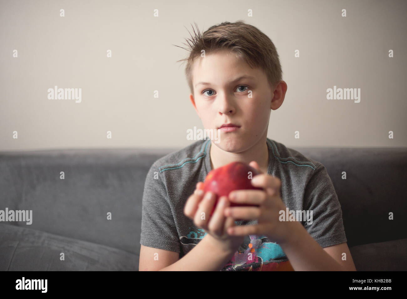 Teenage caucasian boy with red apple. Portrait at home Stock Photo - Alamy