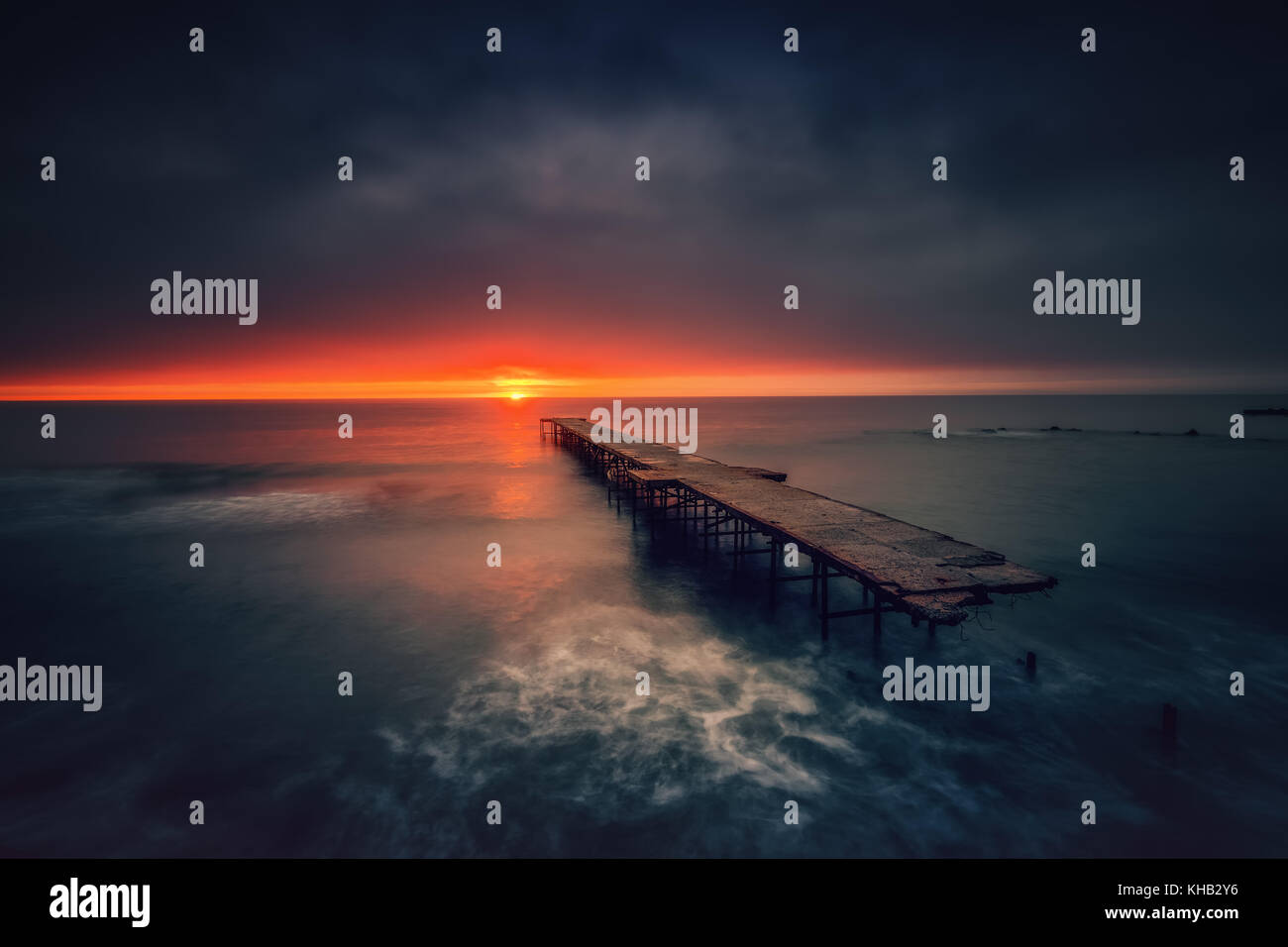 Old broken bridge in the sea, long exposure sunrise shot Stock Photo ...