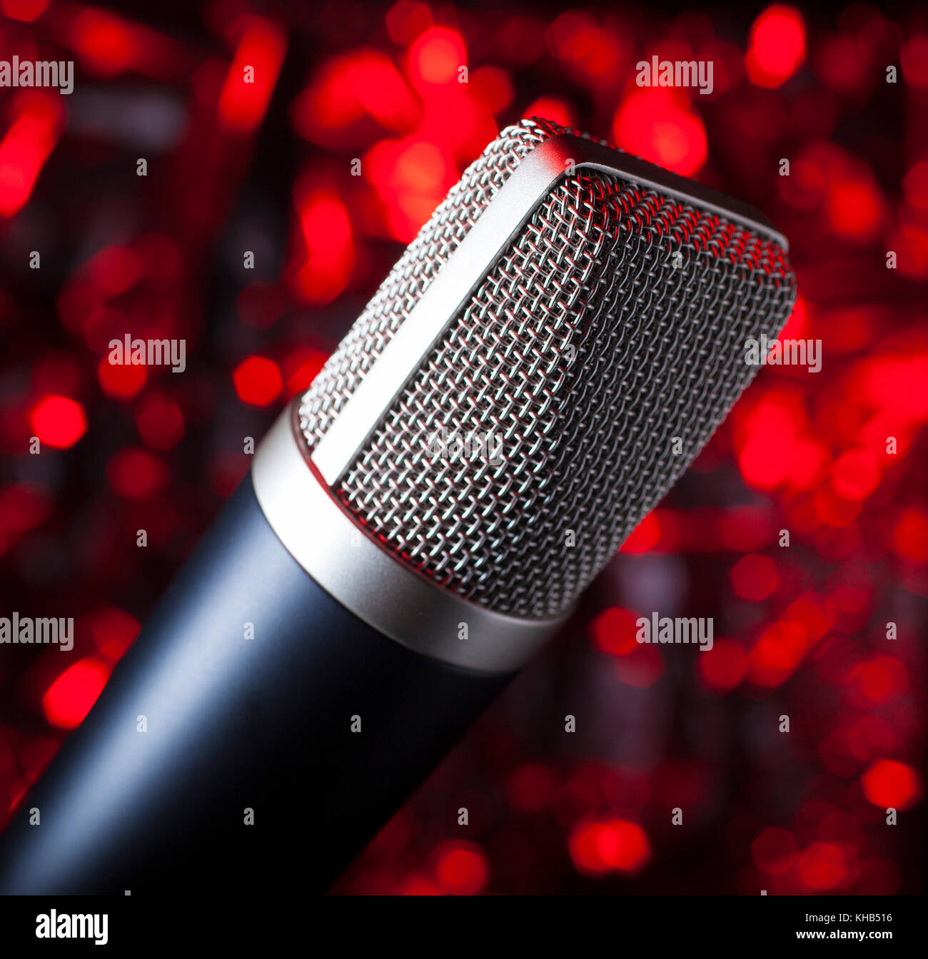 Red and black background behind a mesh covered mike Stock Photo - Alamy