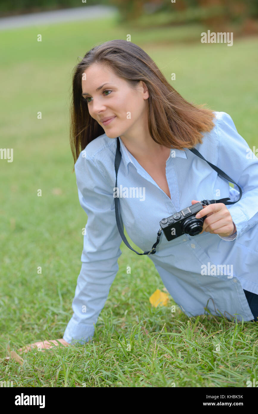 Woman sat on grass with camera Stock Photo - Alamy