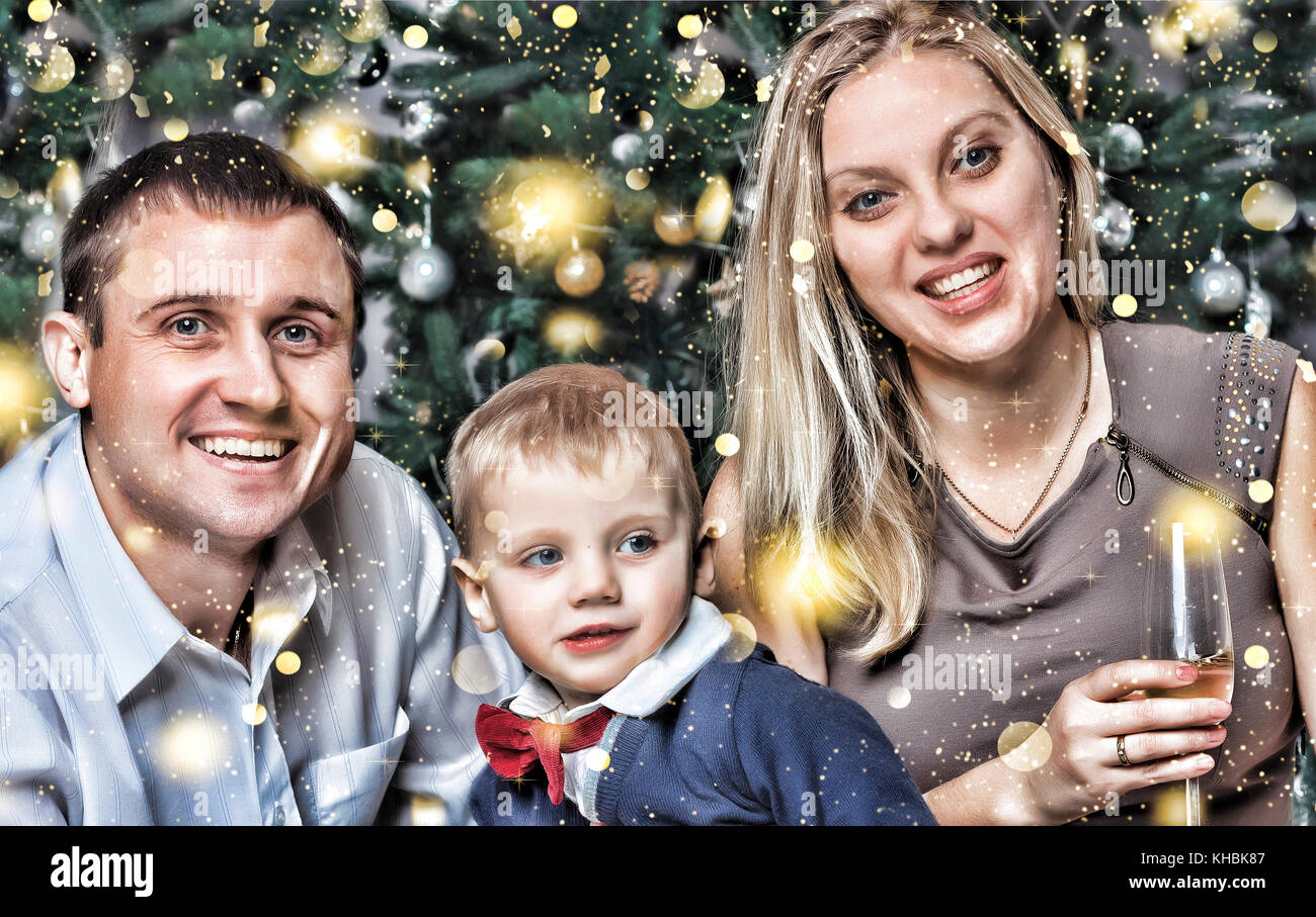 Happy young family with a small son happily smiling meets the new year ...