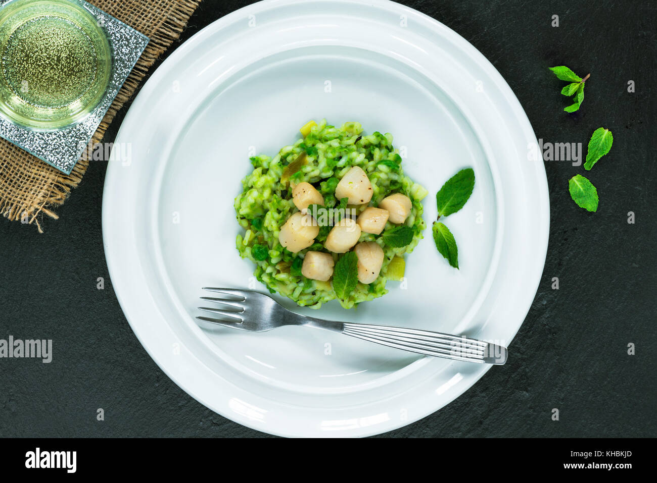 Scallops on minted pea risotto garnished with fresh mint - top view ...