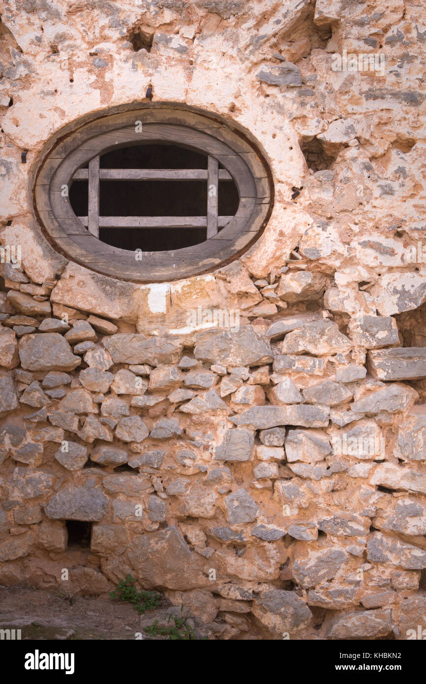 Stone wall with round wooden window of a medieval fortress Stock Photo ...