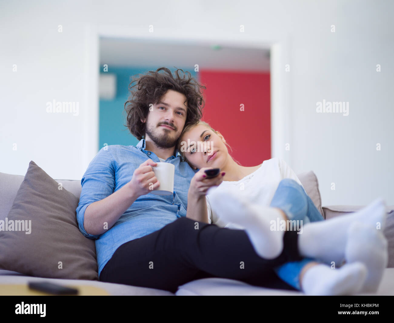 Young couple on the sofa watching television together in their luxury ...
