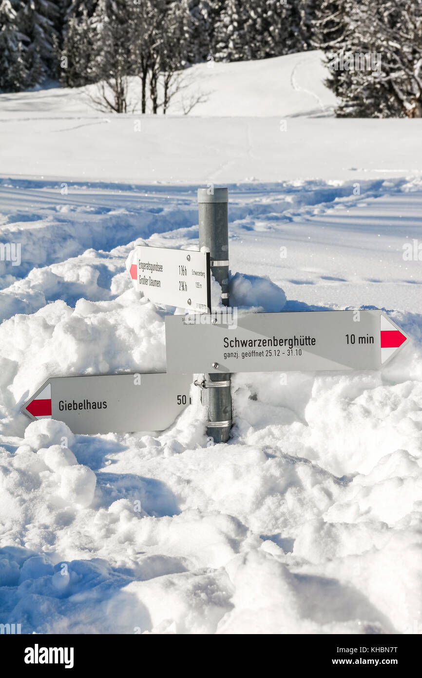 Hiking trail signpost sticks out of deep snow in mountains winter ...