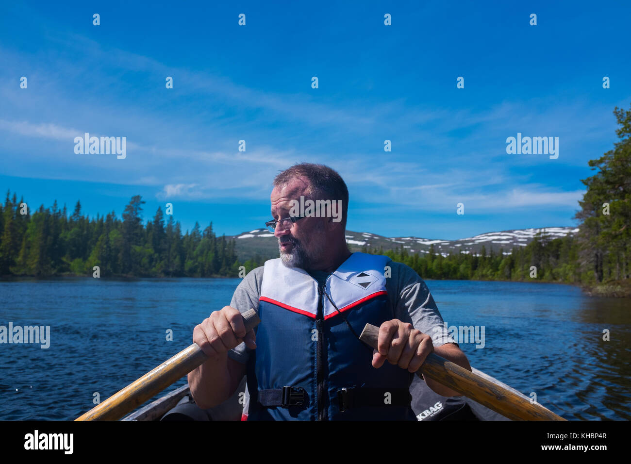 Man rowing a boat in norther sweden at a freshwater lake Stock Photo ...