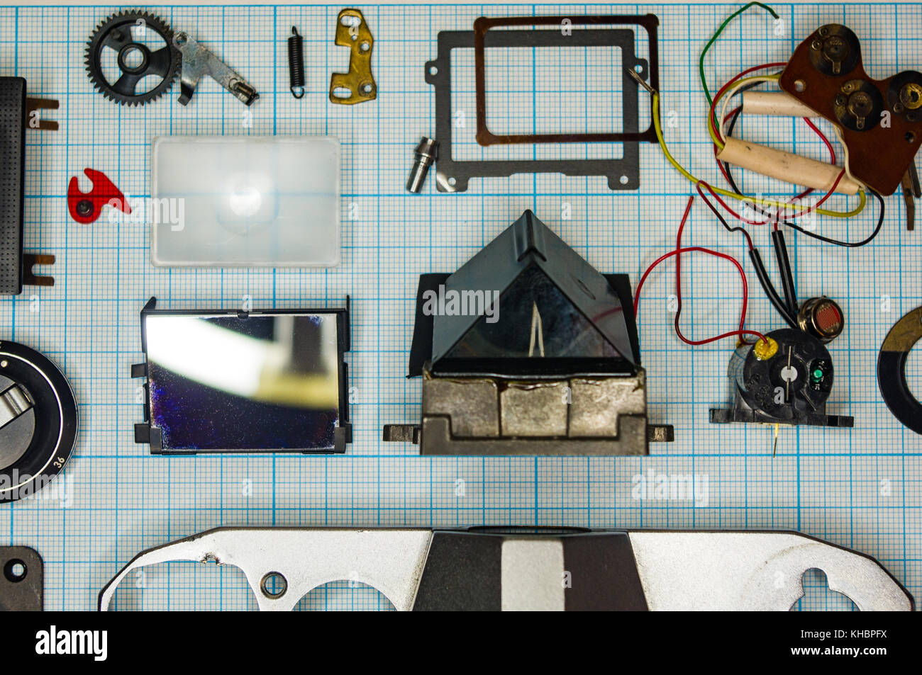 parts are completely disassembled old retro film SLR camera on graph ...
