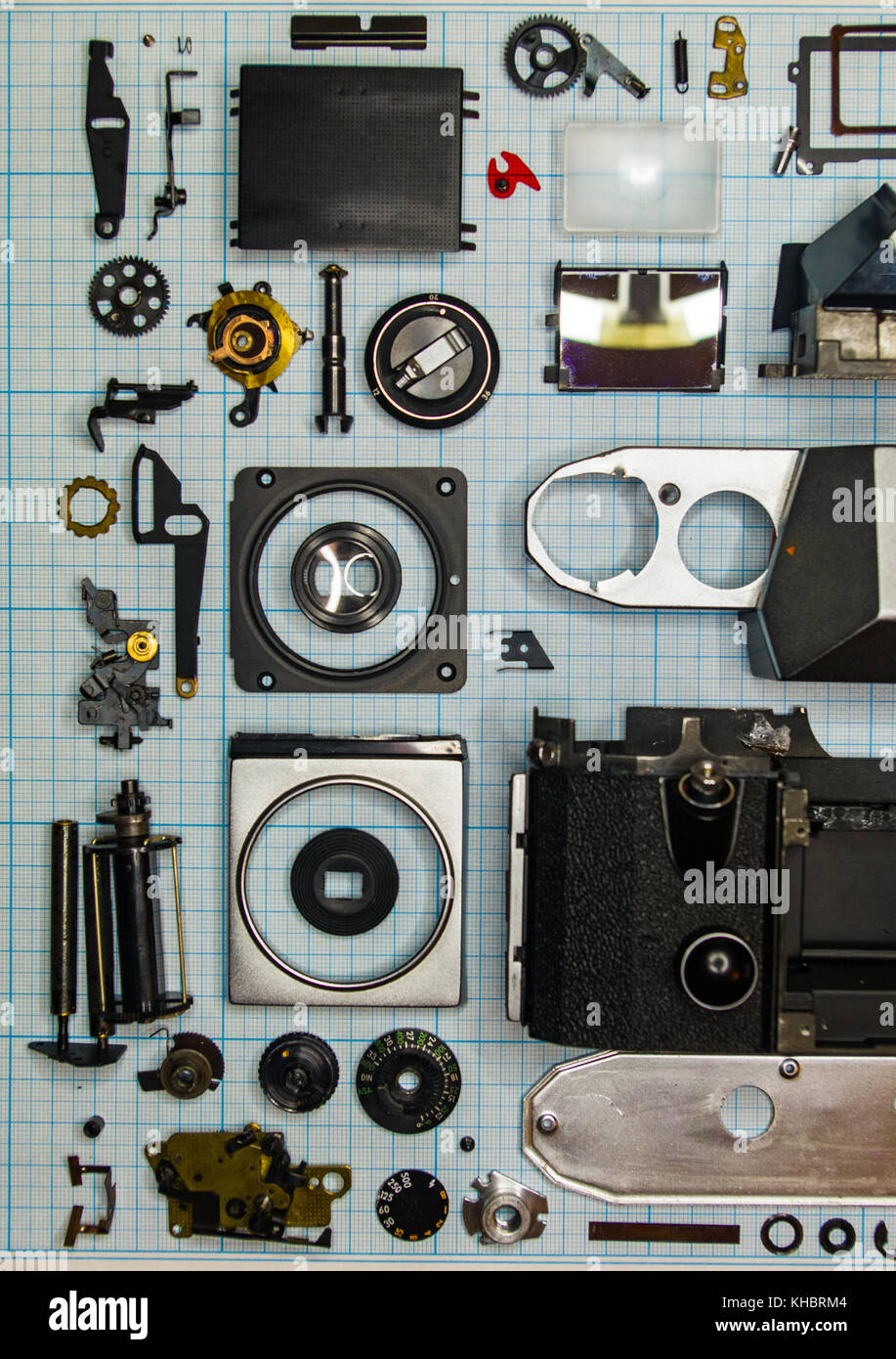 parts are completely disassembled old retro film SLR camera on graph ...
