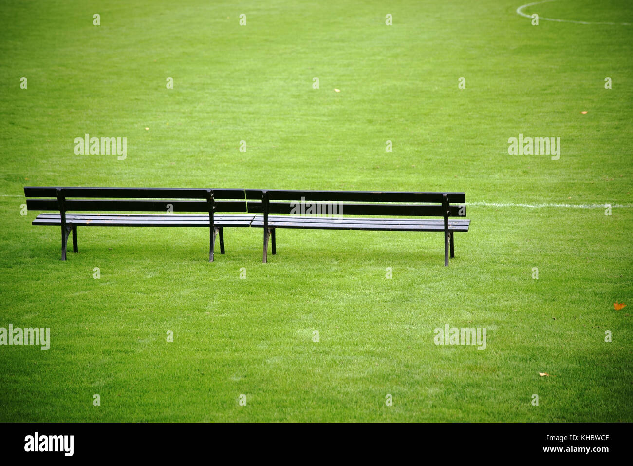 A coach bench stands on the edge of a soccer field in a soccer stadium ...