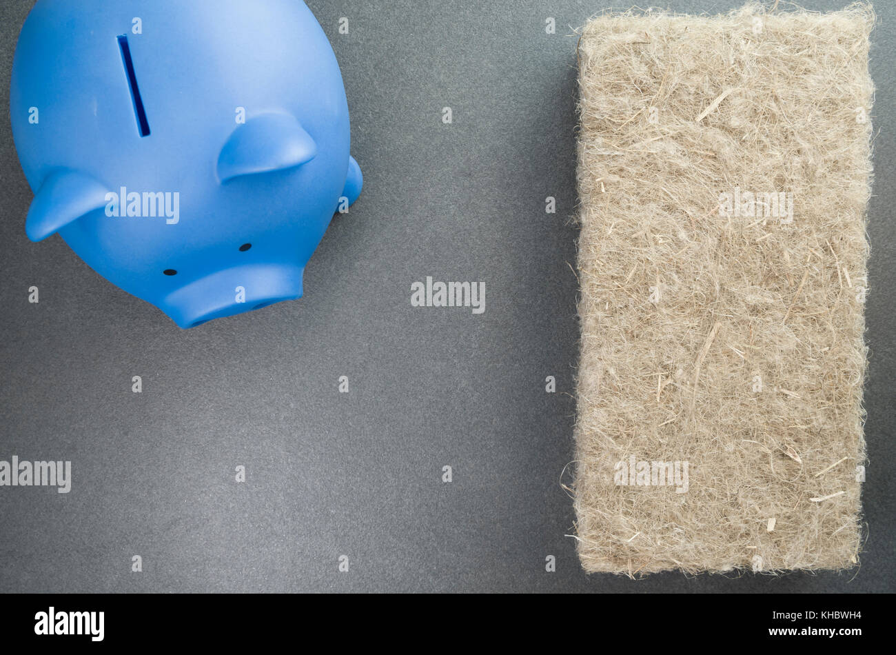 terracotta piggy bank and wall insulation panel on a dark stone ...