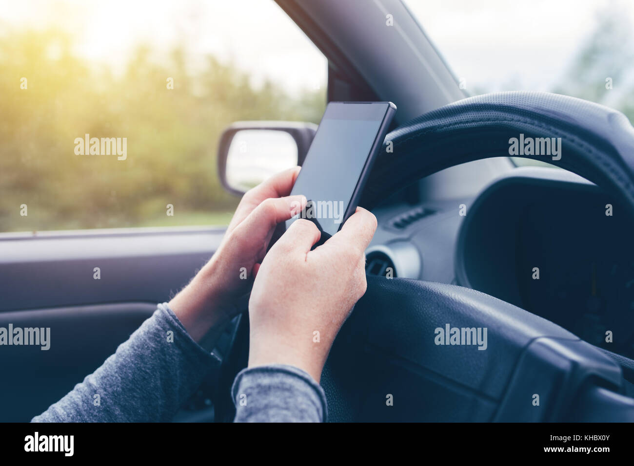Woman simultaneously driving car and typing text message, mobile smart ...