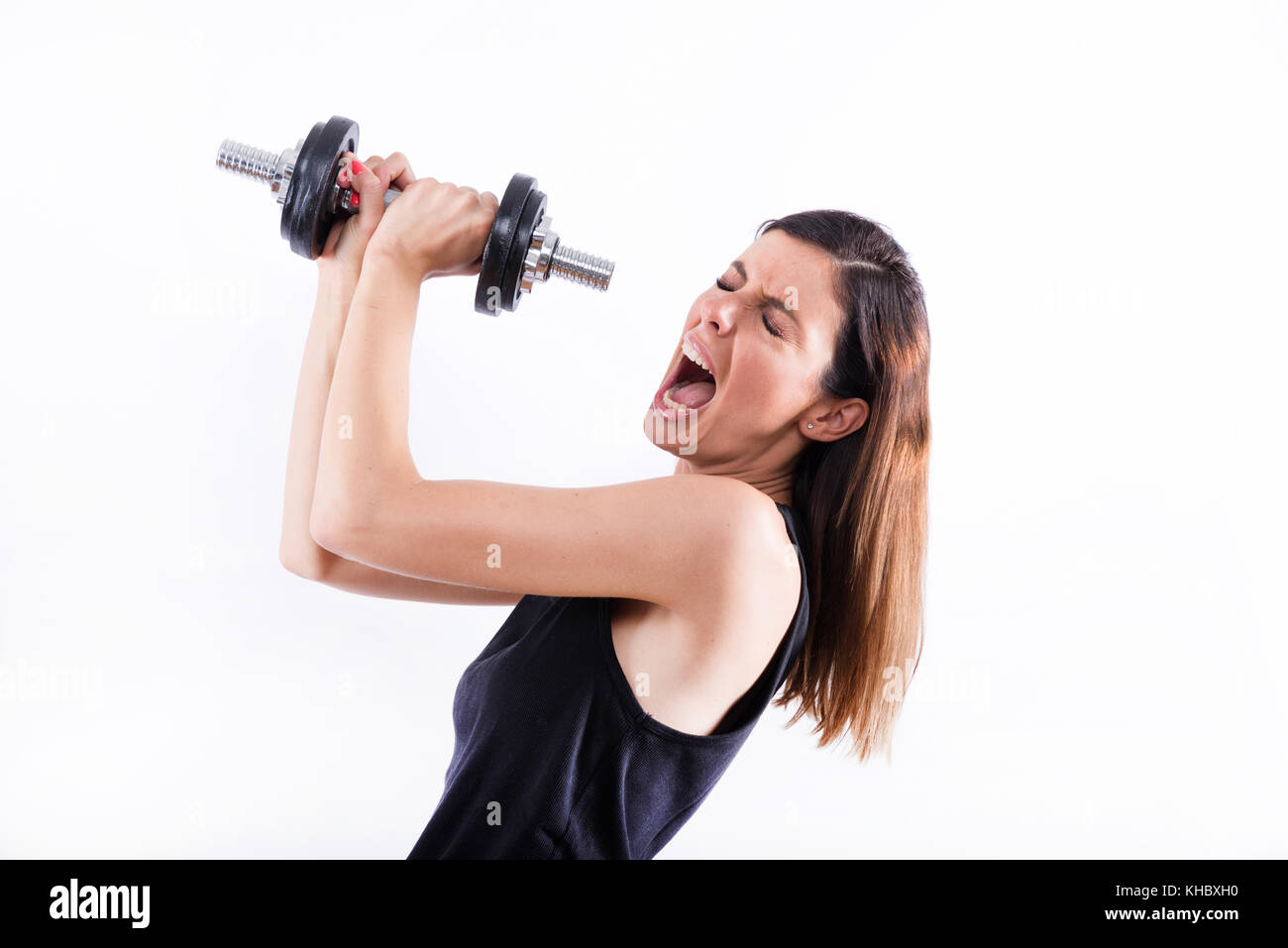 A beautiful young woman lifting weight and screaming Stock Photo - Alamy
