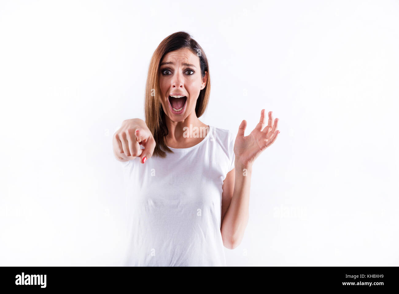 A beautiful young woman pointing to the camera and screaming Stock ...