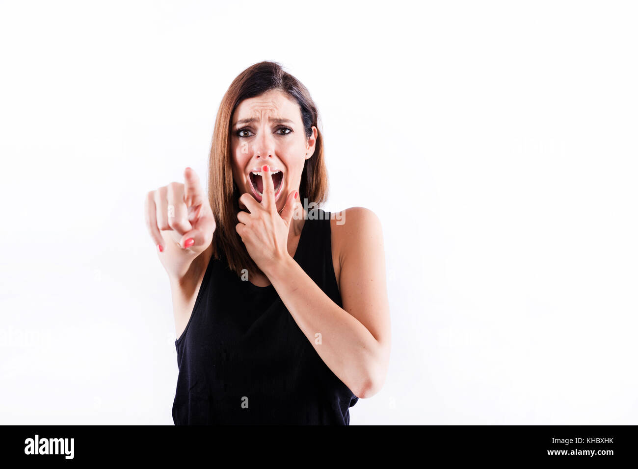 A beautiful young woman pointing to the camera and feeling worried ...