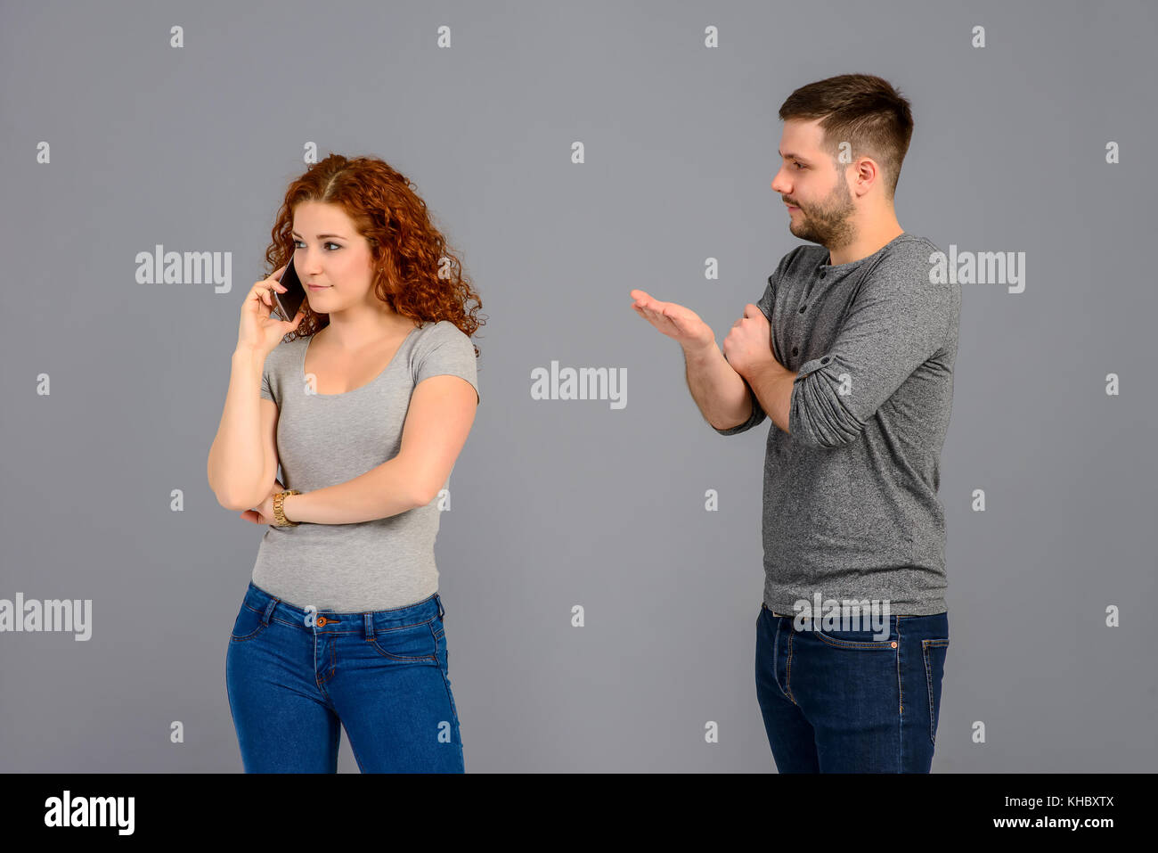 A beautiful young woman standing and talking on her phone and ignoring ...