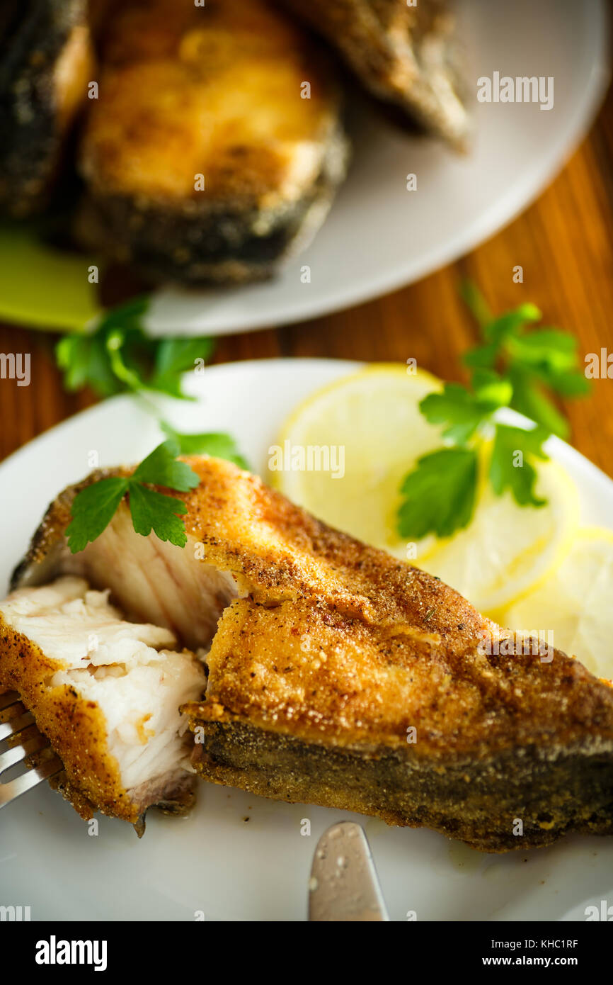catfish roasted in batter on a wooden table Stock Photo - Alamy