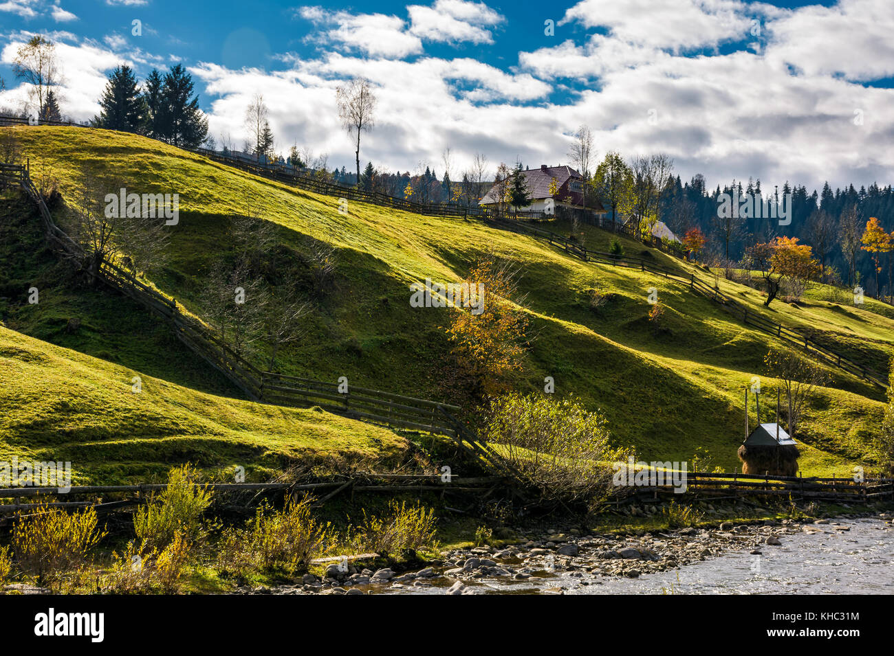 grassy rural hillside near the village in autumn. beautiful countryside ...