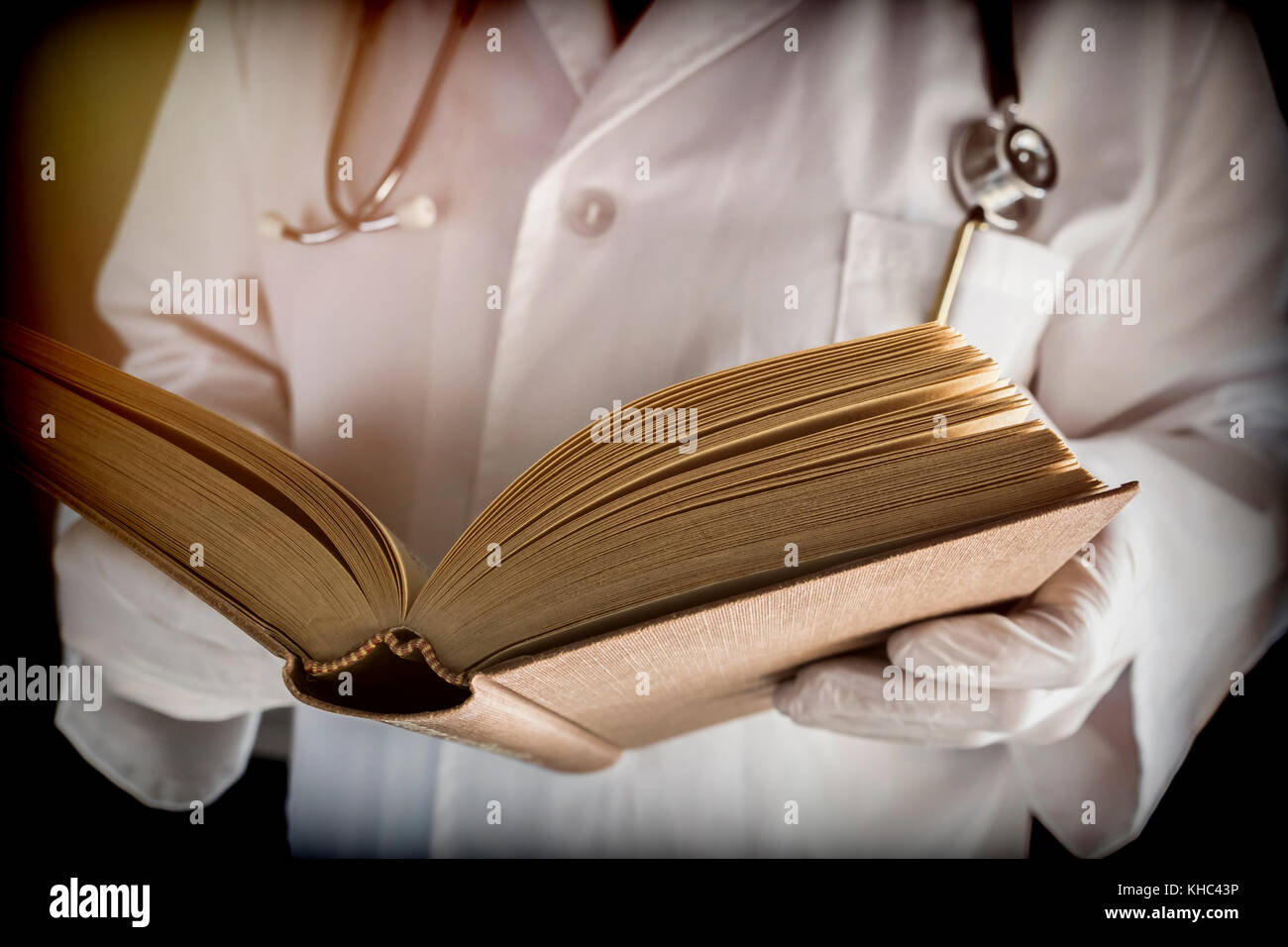 Doctor reads medical book in a hospital. Conceptual image Stock Photo ...