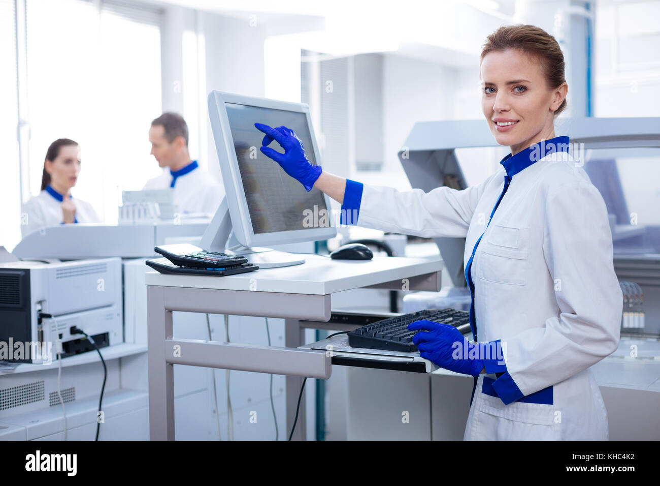 Adorable smiling laboratorian filling the data Stock Photo - Alamy