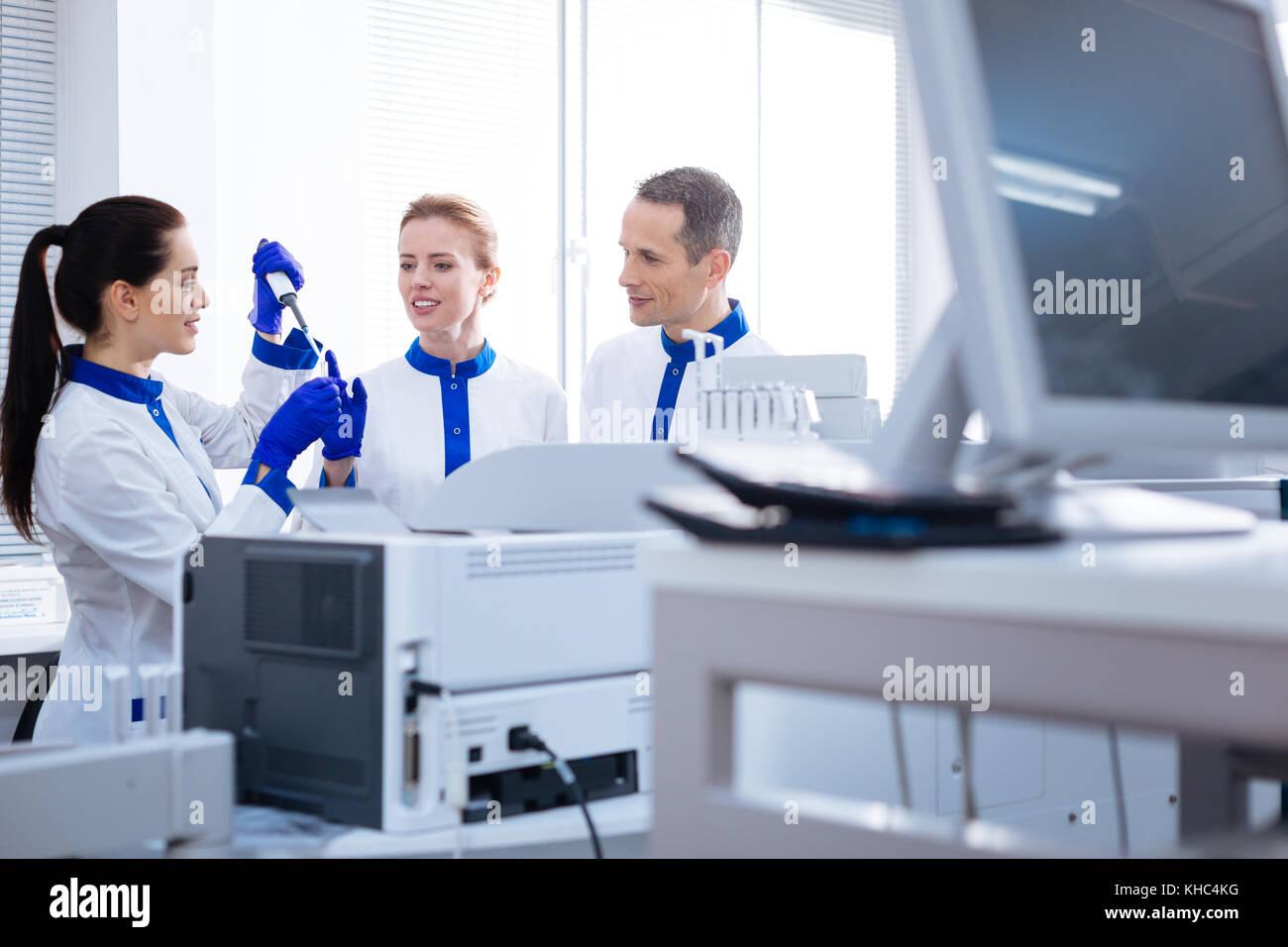 Two wise laboratorians watching at interns work Stock Photo - Alamy