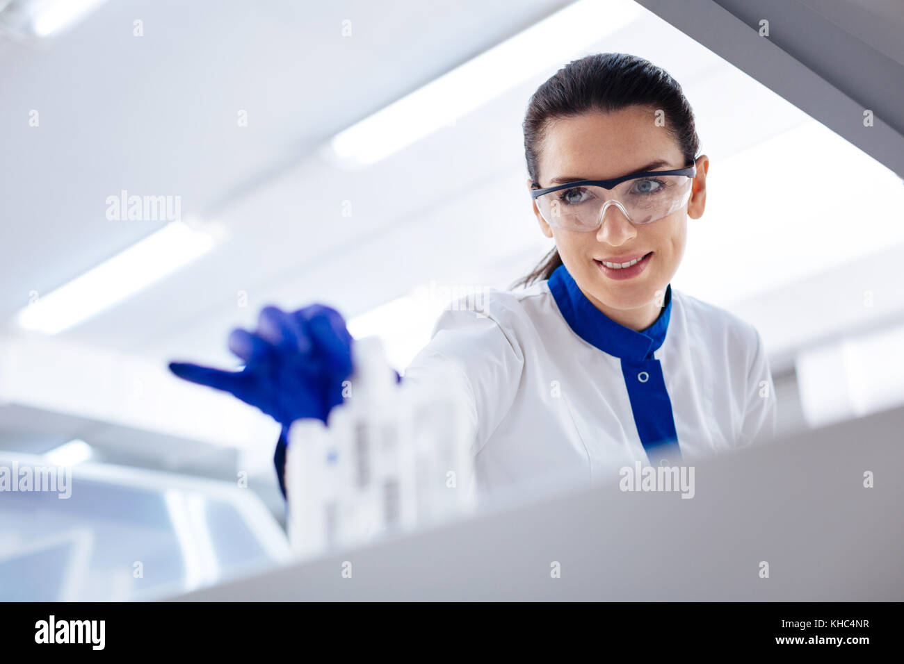 Smiling agreeable researcher searching for reagent Stock Photo - Alamy