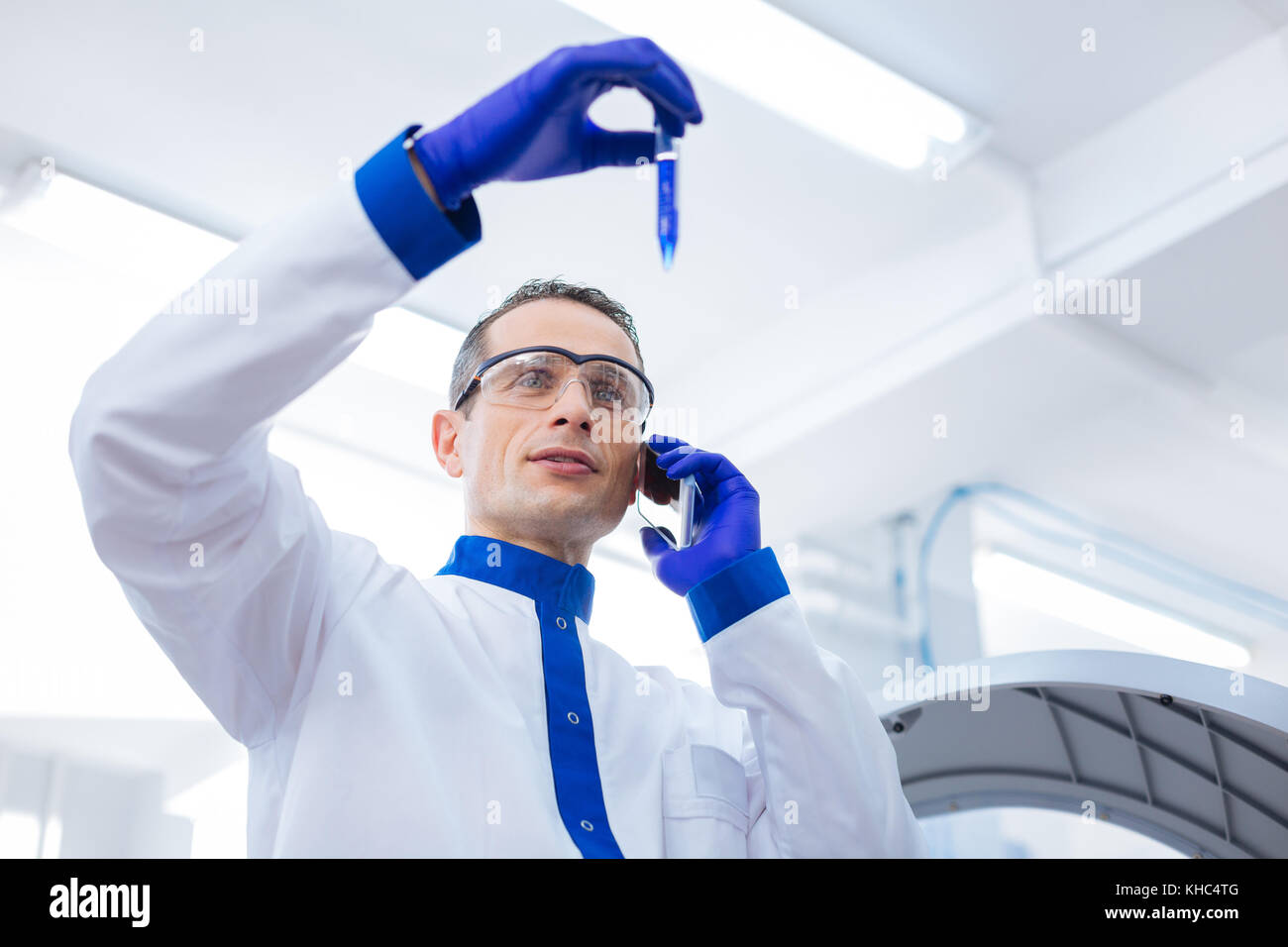 Positive pensive researcher taking on the phone Stock Photo - Alamy