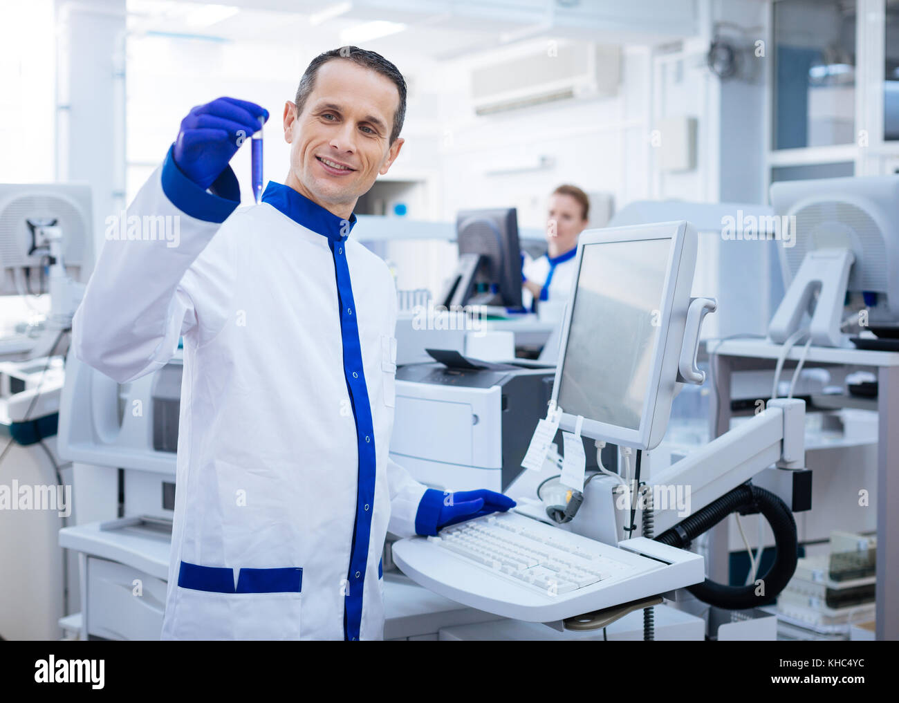 Budding good looking researcher conducting experiment Stock Photo - Alamy