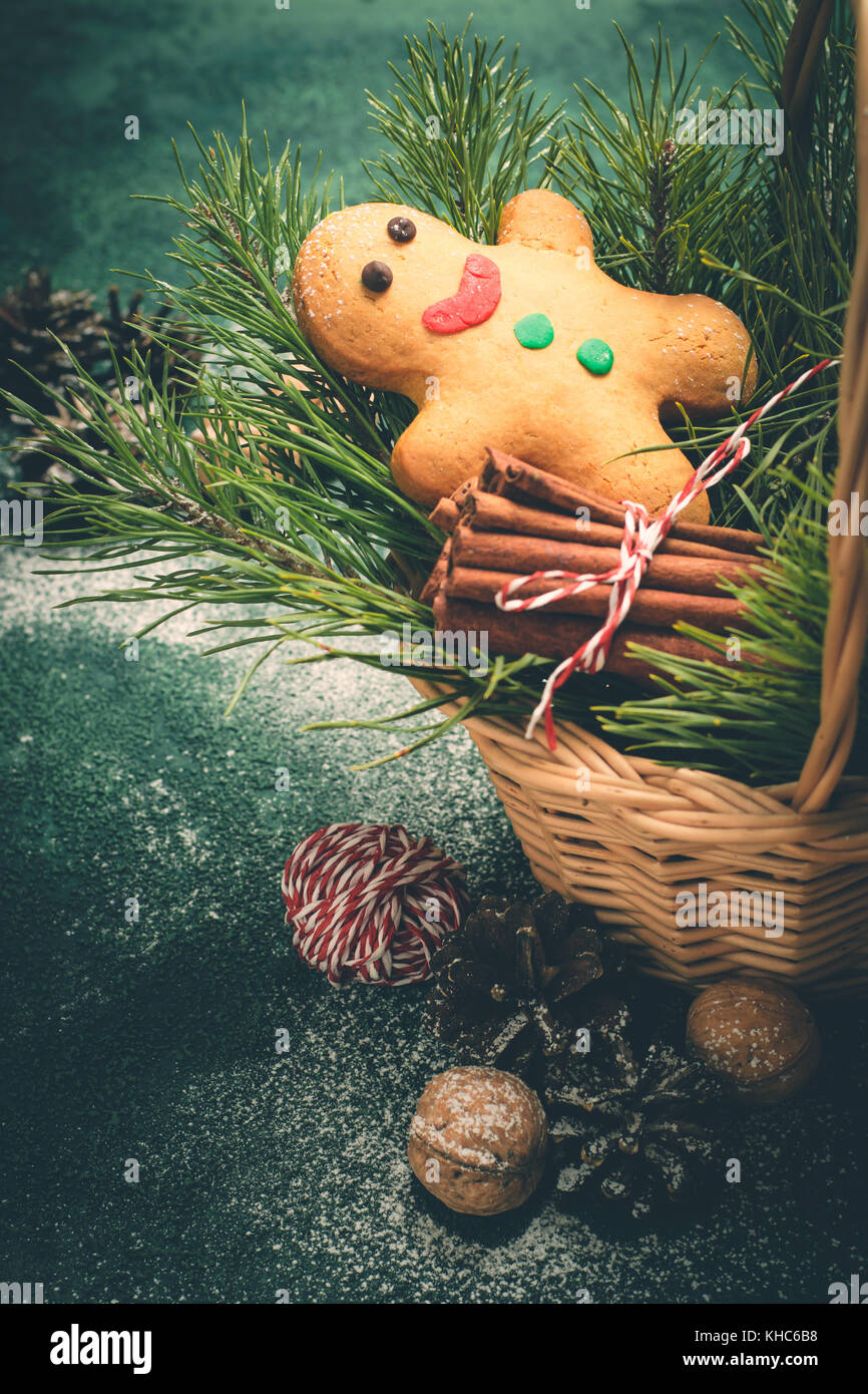 Christmas card with gingerbread man and coniferous branches in basket ...