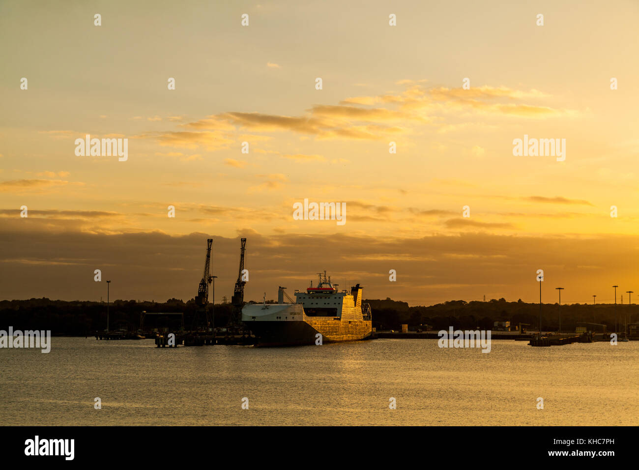 Sunset with cargo ship Stock Photo - Alamy