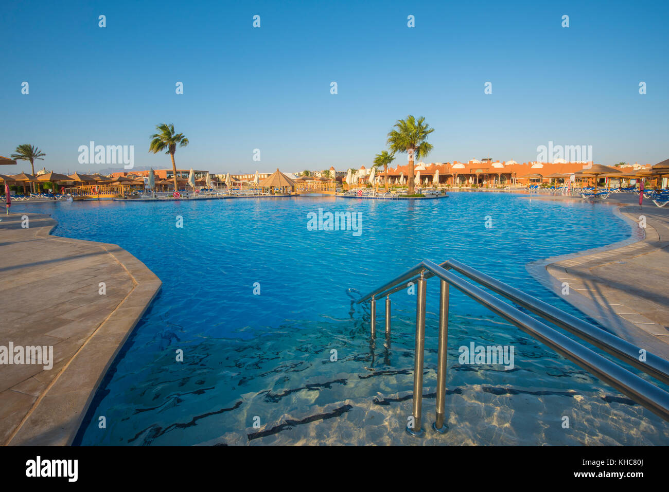 Large swimming pool with entry steps and railing at a luxury tropical ...