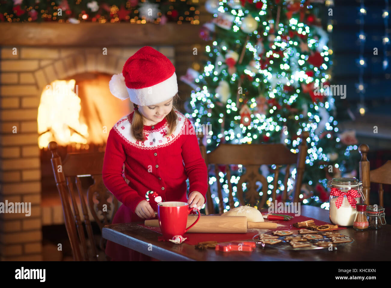 Child baking Christmas cookies at fire place and decorated tree. Kids ...