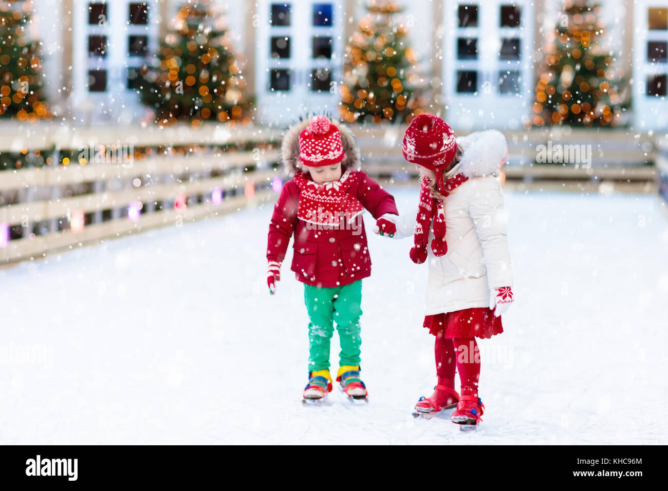 Kids ice skating in winter park rink. Children ice skate on Christmas ...