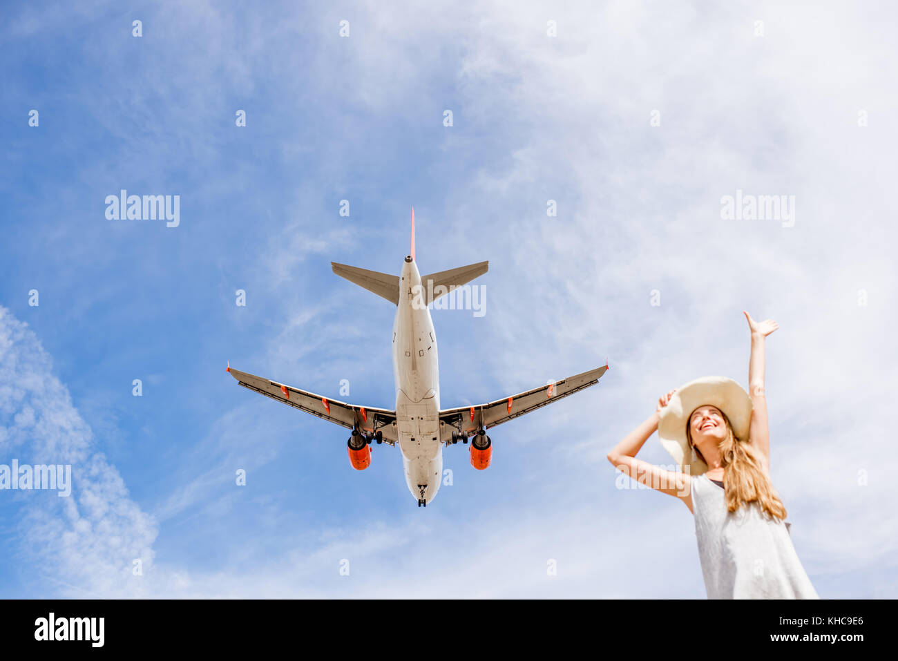 Young and happy woman enjoying the airplane flying in the sky. Image ...