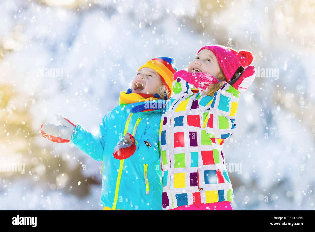 Kids playing in snow. Children play outdoors on snowy winter day. Boy ...