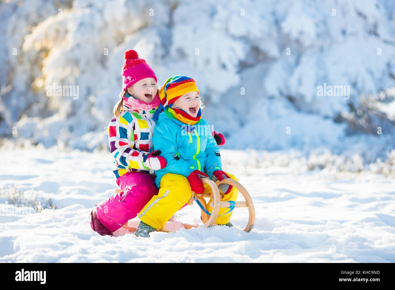 Little girl and boy enjoying sleigh ride. Child sledding. Toddler kid ...