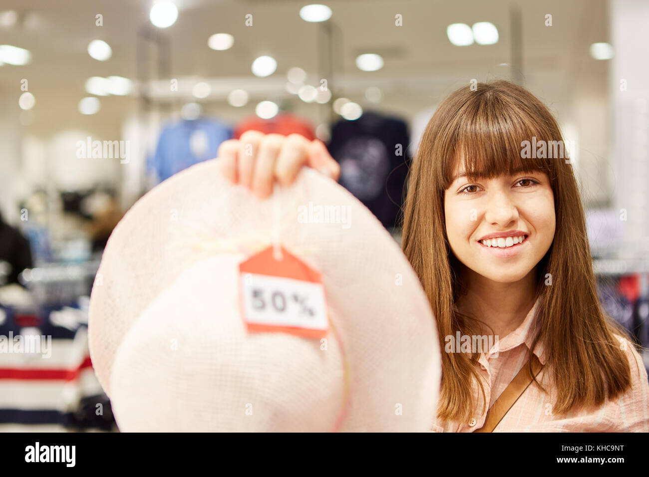 Young woman as a customer is happy about fashion with 50% off discount ...