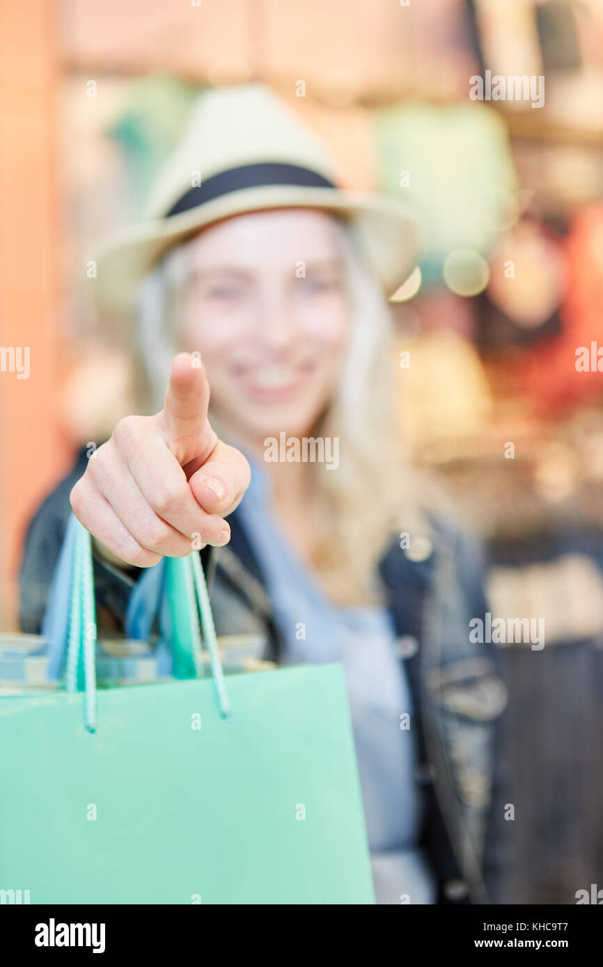 Young woman shopping points finger in one direction Stock Photo - Alamy