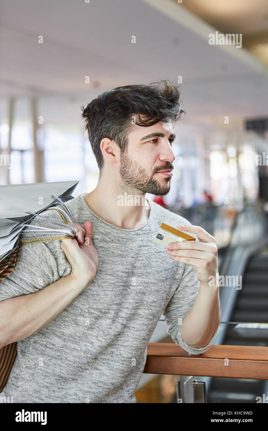 Young man with a credit card in retail shopping mall Stock Photo - Alamy