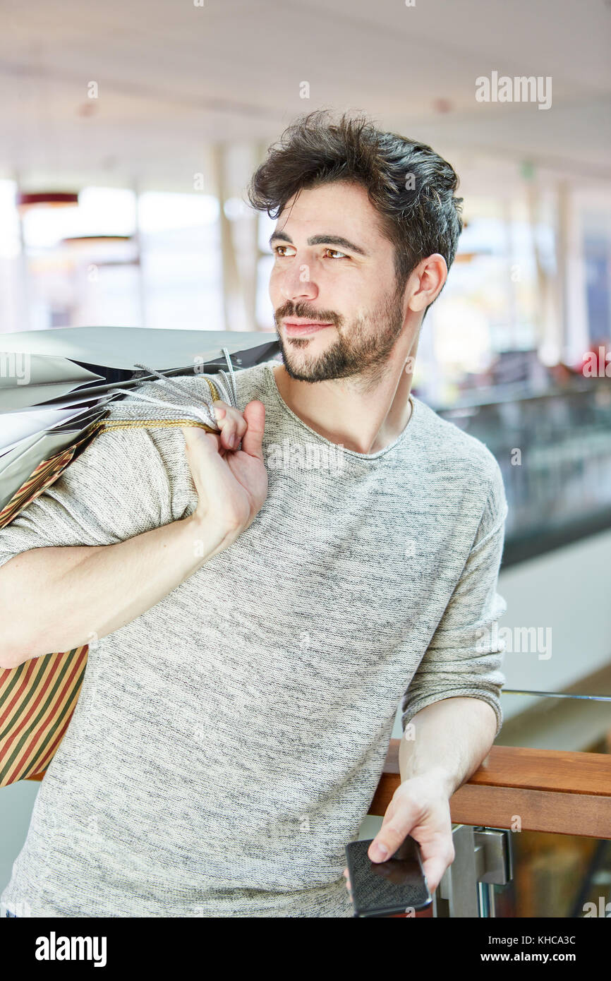 Young man with shopping bags while shopping in shopping mall Stock ...