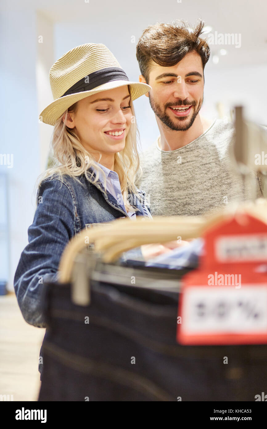 Young couple is looking for suitable clothes while shopping in fashion ...