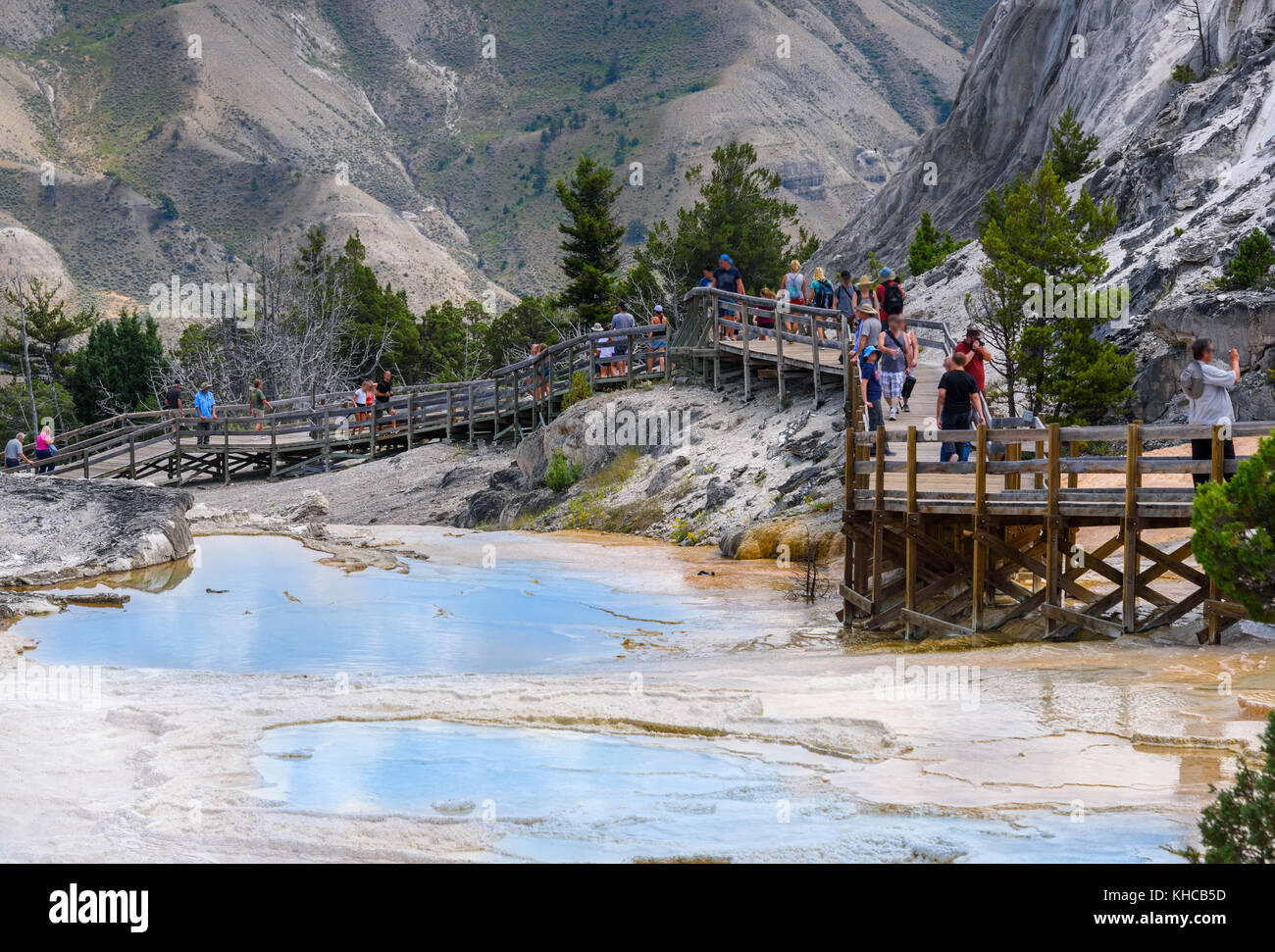 Mammoth hot springs pools with boardwalk, walkway. Tourists, people ...